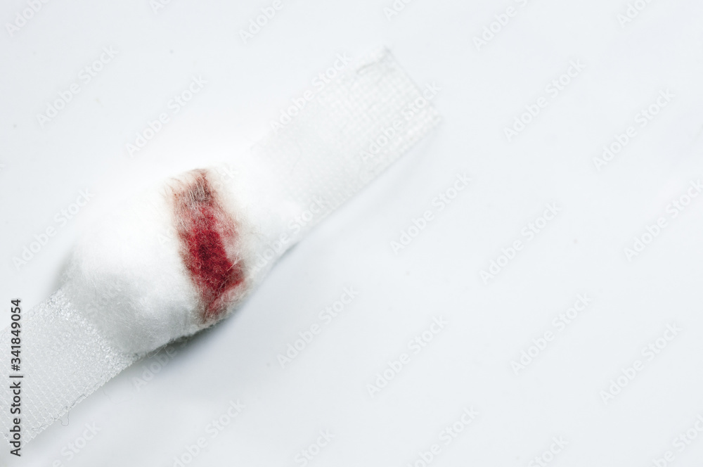 Blurred blood on cotton wool and white plaster on white background ...