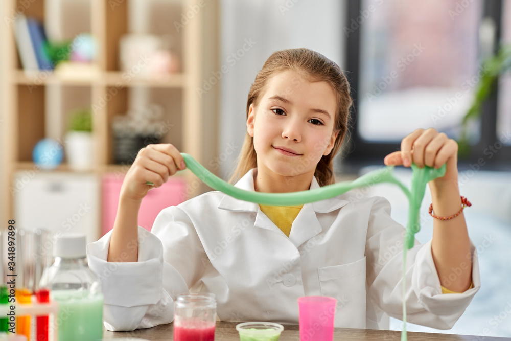 science, childhood and chemistry concept - girl playing with slime at ...