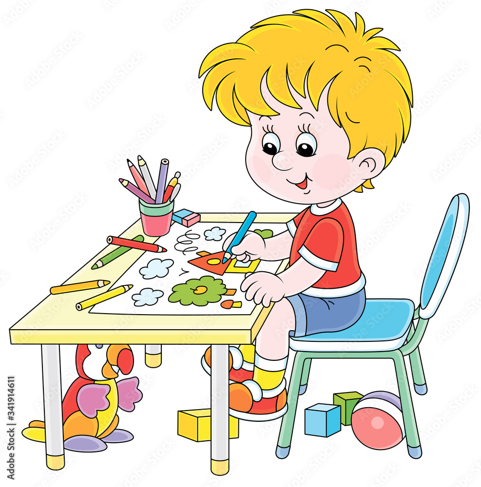 Smiling little boy sitting at his table and drawing with color pencils ...