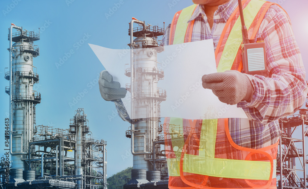 Worker in Oil Refinery discussion inspection by hand holding blueprint ...