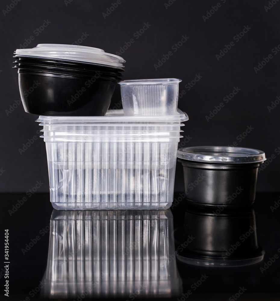 Plastic containers on a black background. Recycling plastics. Reusable ...