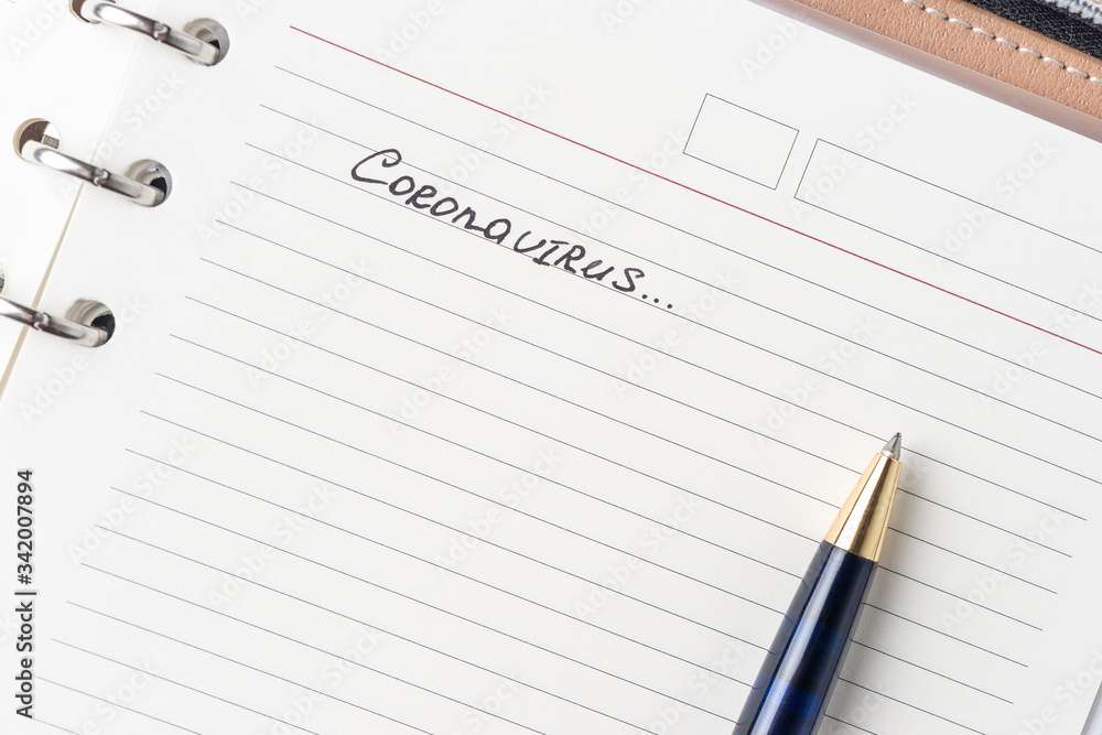 Coronavirus Covid-19 text hand-written on empty sheet in a daily ...