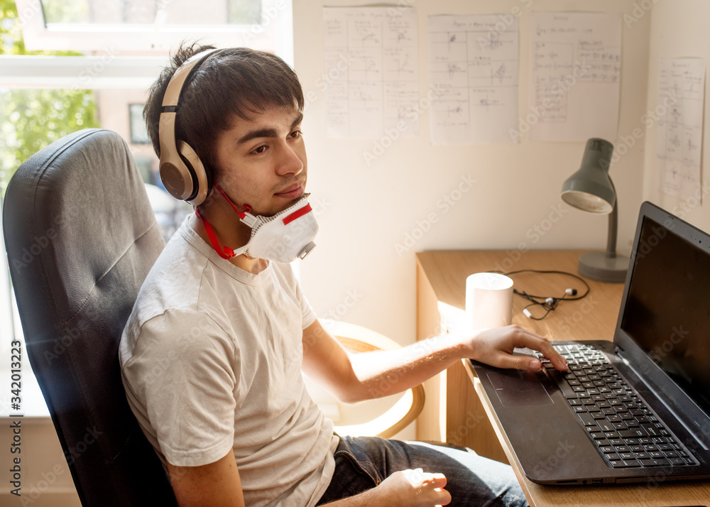 One sad Boy sitting on his chair wearing white shirt, jeans, white mask ...