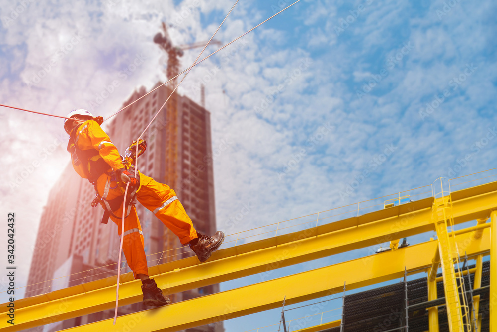 Rope access, Abseiling worker on high wear dresses and safety man with ...