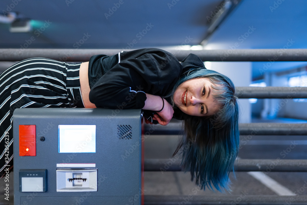 Female Model Laying over ticket counter in parking garage and smiling ...