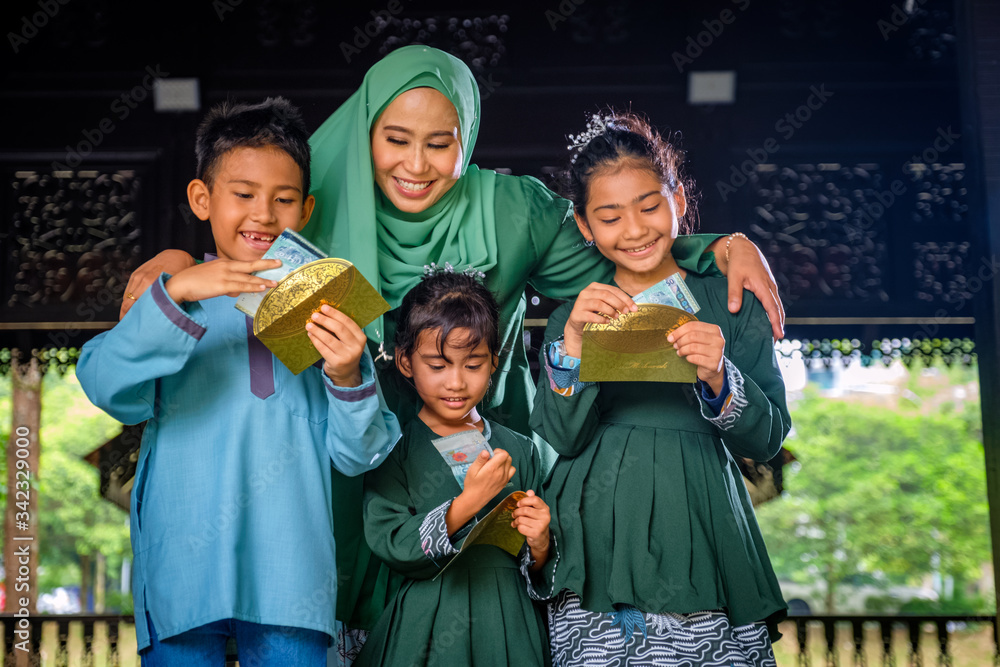 Happy children holding an envelope of pocket money or raya angpao from ...