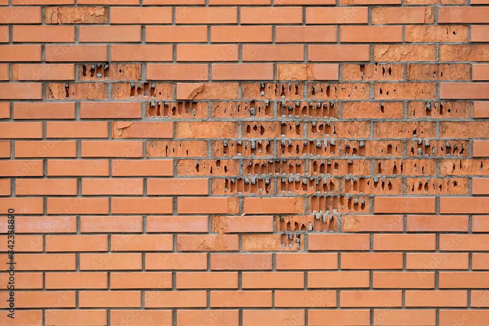 Red brick crumbles in the wall. The facing brick crumbles. Destruction ...