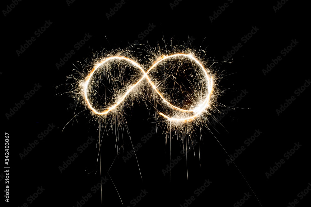 Infinity symbol by light painting with fireworks in isolated natural ...