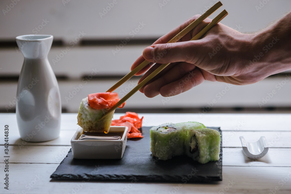 Japanese traditional rolls served in a sushi bar on white table. Close ...