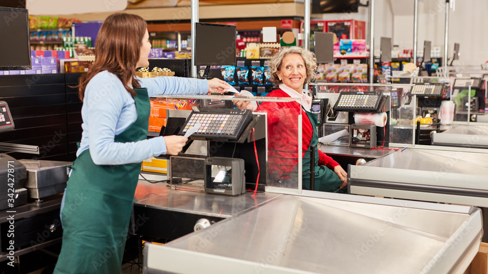 Two women at the supermarket cashier as a team Stock Photo | Adobe Stock