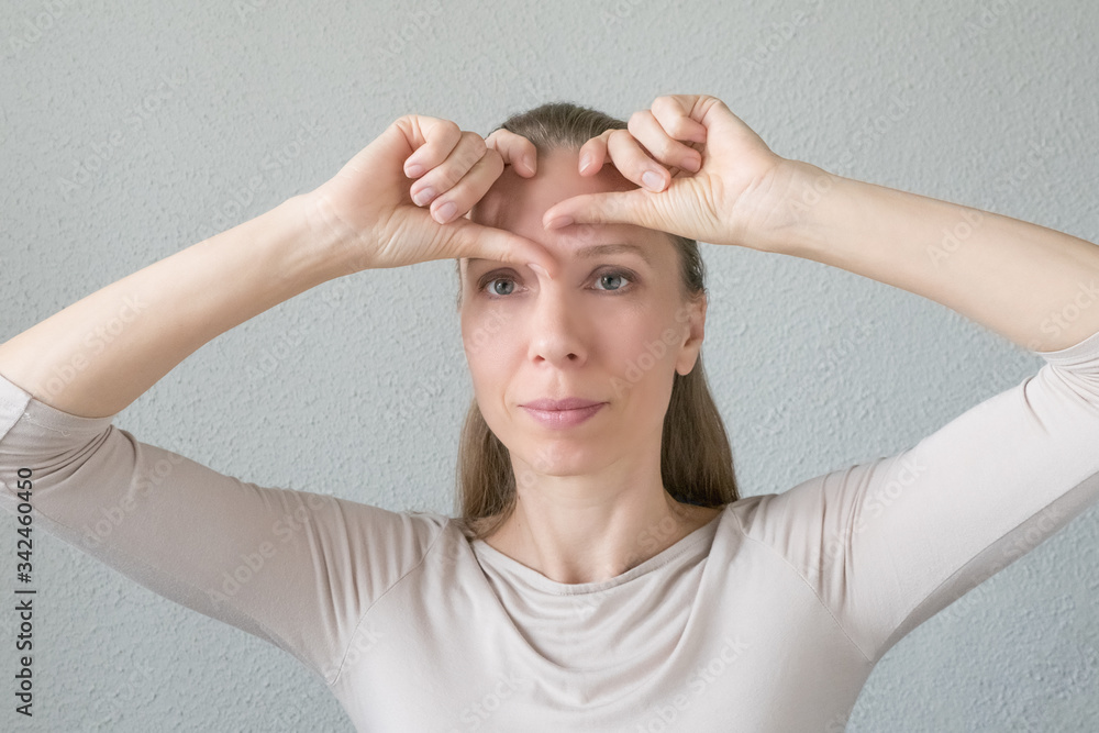 Gymnastics for the face. Woman does rejuvenating exercises for the face ...