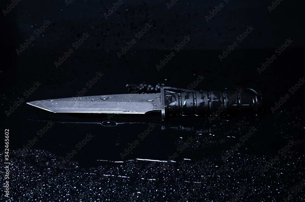 Foto de Large army knife with a fixed blade and a drop of water. Drops ...