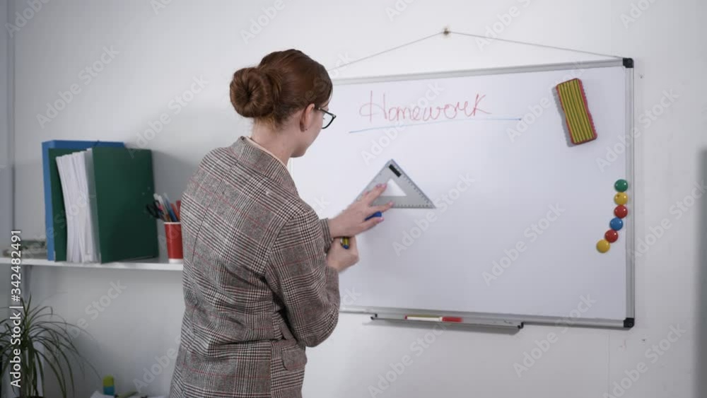 homework, female teacher draws a triangle on a magnetic blackboard with ...