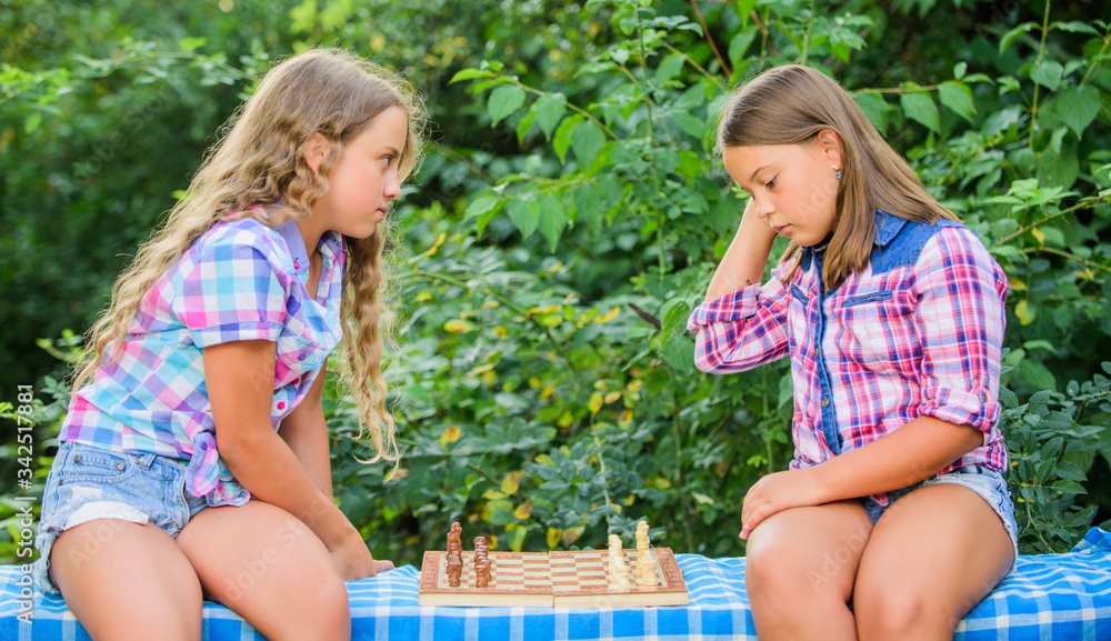 Foto de Think better. Little girls play chess. Sisters playing chess ...