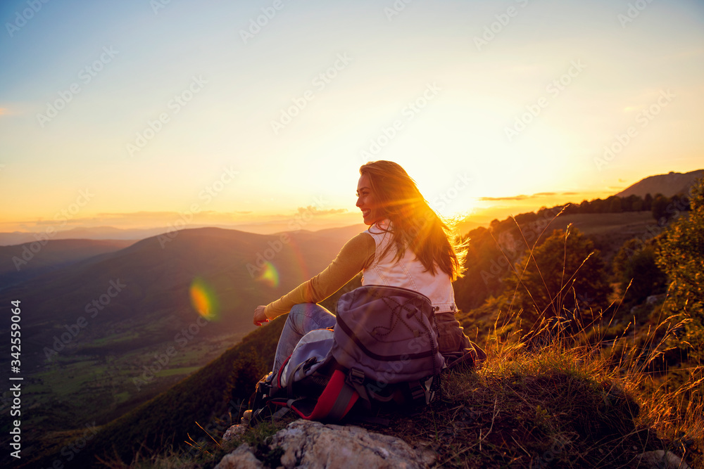 Young woman rise hand up on top of mountain and sunset sky abstract ...