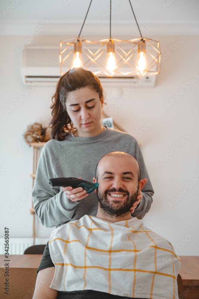 young handsome man and beautiful woman cutting her hair and beard with ...