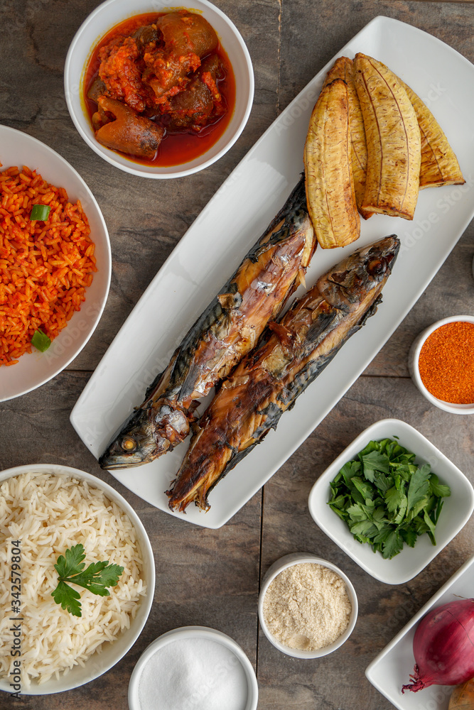 Grilled fish curry with plantain and salad. African national dish ...