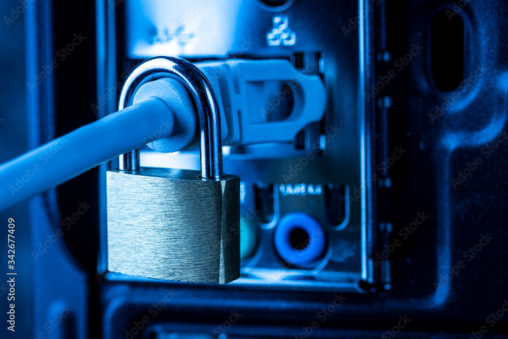 Closed lock hanging on a network cable plugged into a computer. The ...