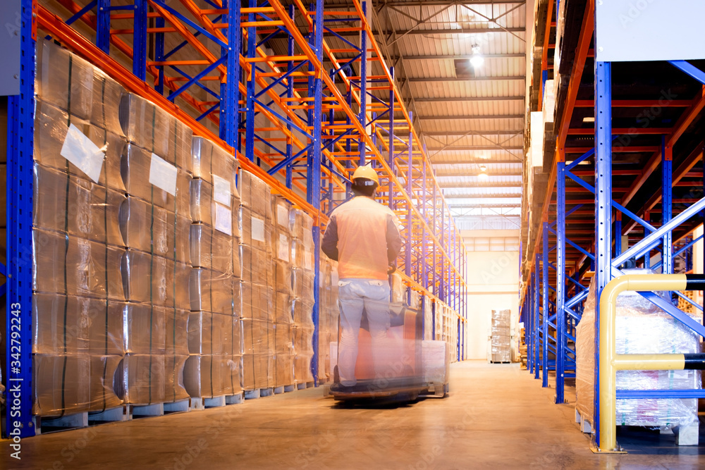 Interior of storage warehouse with tall shelves, forklift diver ...