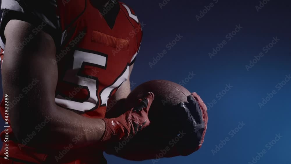 Faceless American football player holding ball ready for game and ...