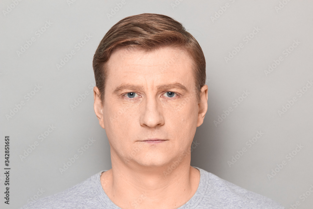 Foto de Portrait of blond mature man with neutral calm expression on ...