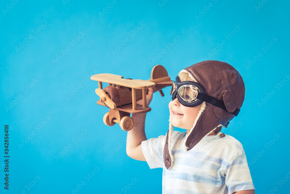 Happy child playing with toy wooden airplane Stock Photo | Adobe Stock