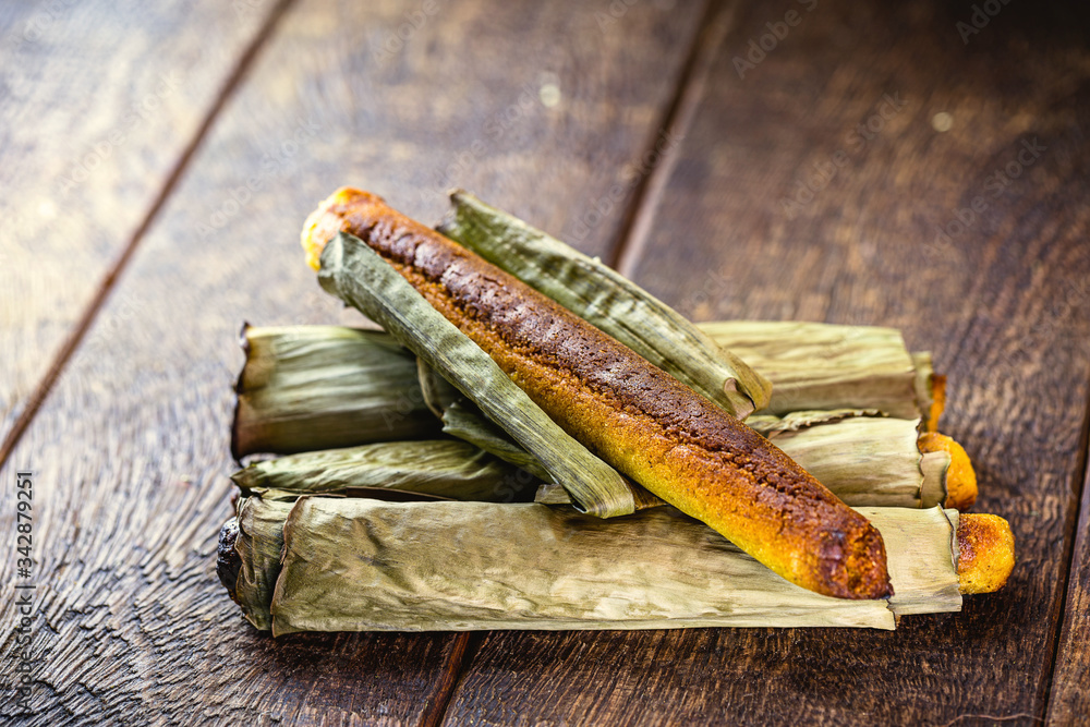 Broa made with corn and wrapped in banana leaf. Typical Brazilian ...
