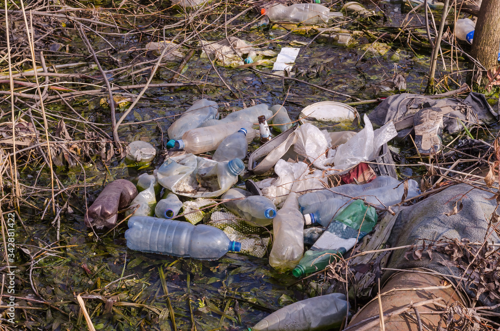 Pollution of a reservoir, lake, river. Plastic bottles and trash ...