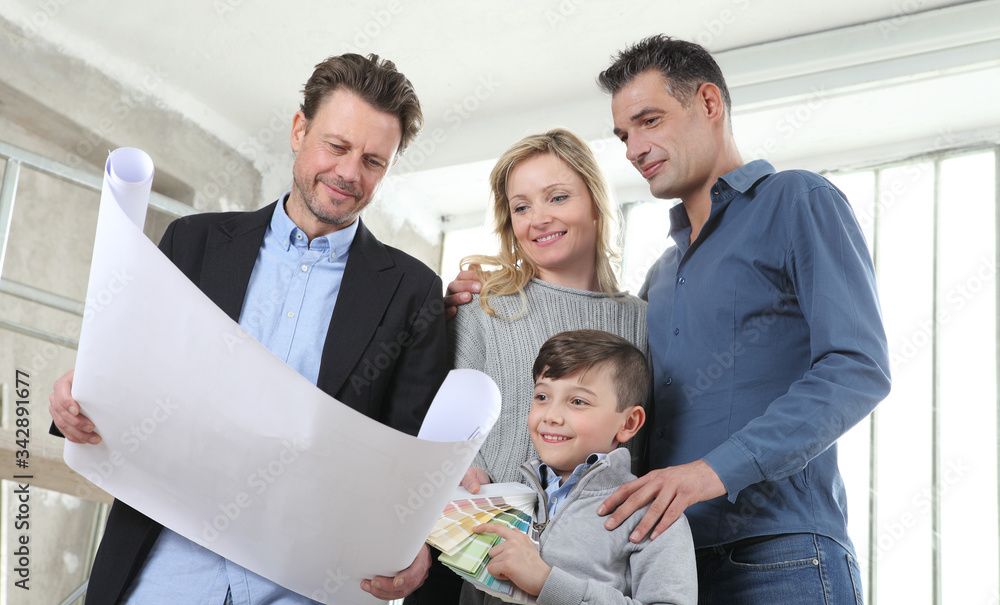 Architect showing house design plans to a family with child. Meeting at ...