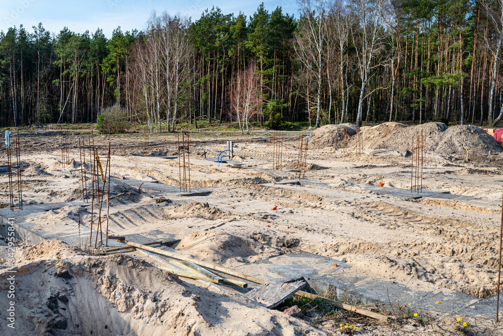 Reinforcing rods protruding from the ground in a place where there will ...