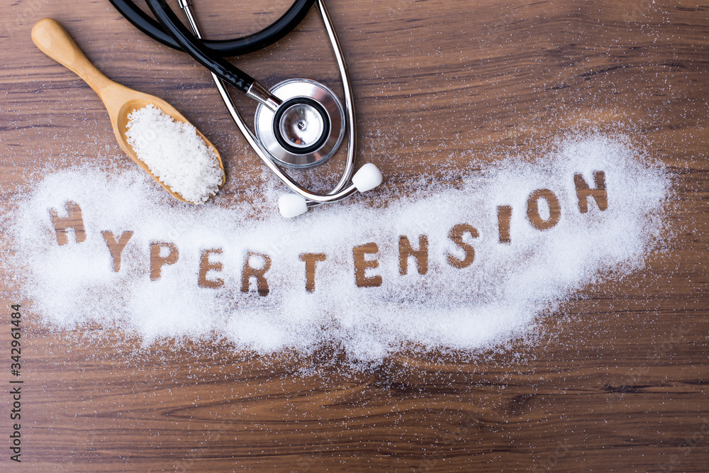 White granulated natural sea salt in wooden scoop and words ...