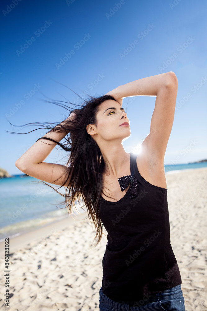 Bellissima modella in costume nero da mare fotografata in spiaggia in ...