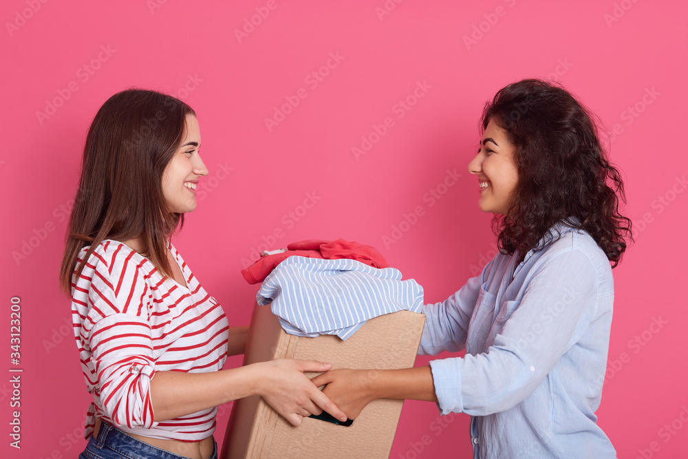 Indoor shot of two attractive women posing isolated over rosy ...