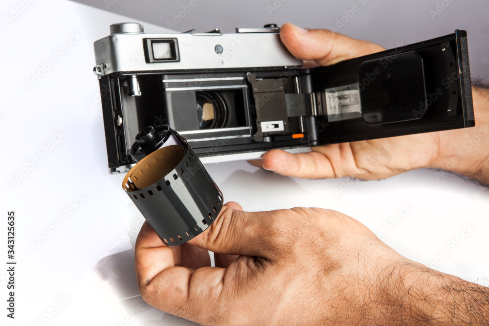 vecchia reflex analogica alla quale viene applicato il rullino vergine ...