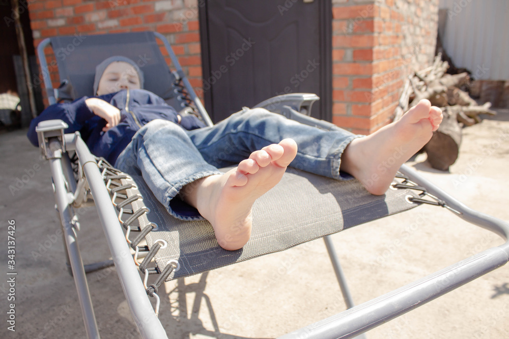 Foto de the boy's bare feet on the chaise longue. resting boy in the ...
