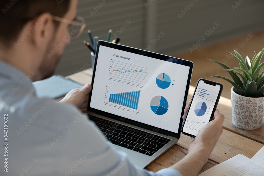 Close up businessman working with statistics, looking at laptop and ...