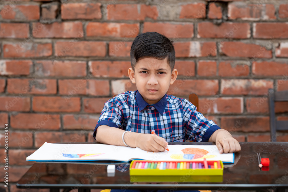Indian schoolkid in uniform drawing and learning painting in classroom ...