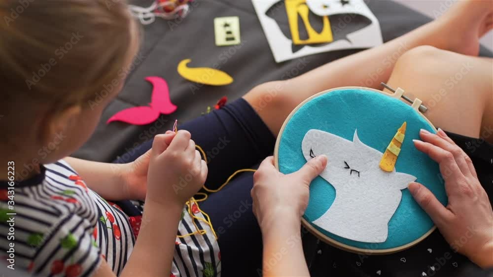 Little Girl Threading a Needle While Embroidering a Unicorn on Felt ...