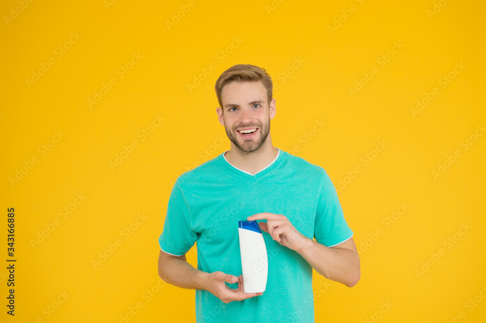 friendly shop assistant. happy man hold shampoo bottle. guy washing ...
