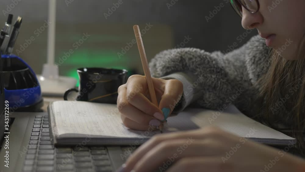 Close-up, teenage girl doing homework on the distance learning front of ...