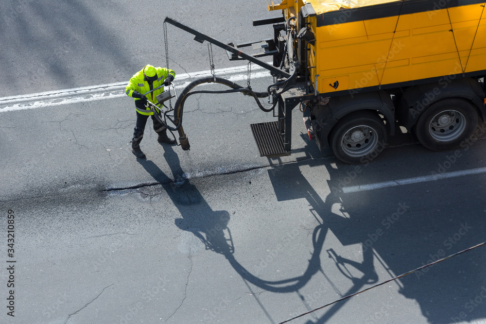 Foto de Road surface restoration work. The worker performs on road ...