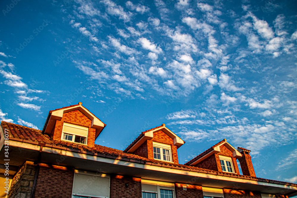 Amaneciendo, plano contrapicado de edificio con tres buhardillas, fondo ...