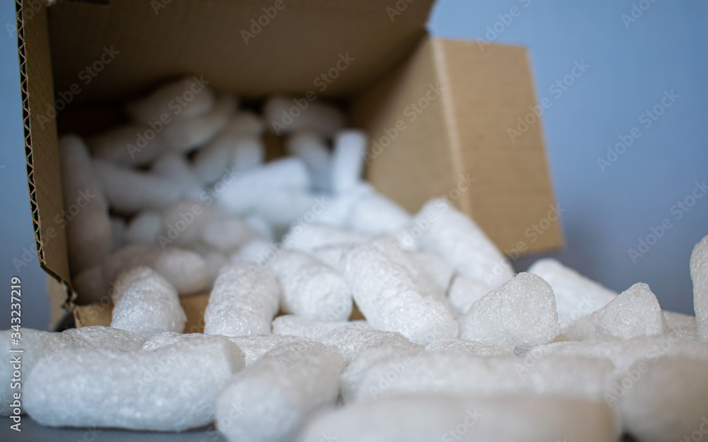 Open cardboard box with white styrofoam filling pieces comming out ...