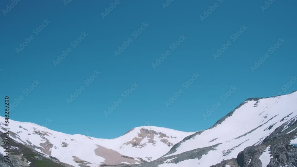Tilt down from sky to reveal high altitude Laguna Negra and snow-capped ...