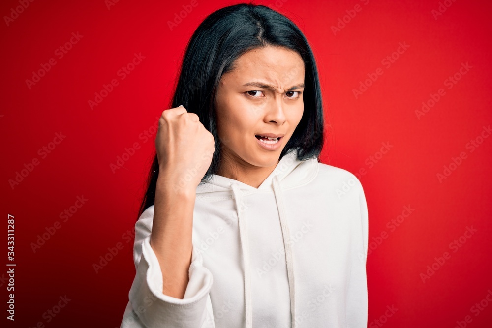 Young beautiful chinese sporty woman wearing sweatshirt over isolated ...