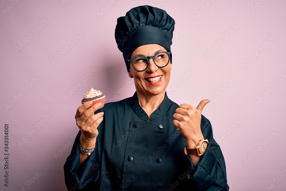 Middle age baker woman wearing cooker uniform and hat holding delicious ...