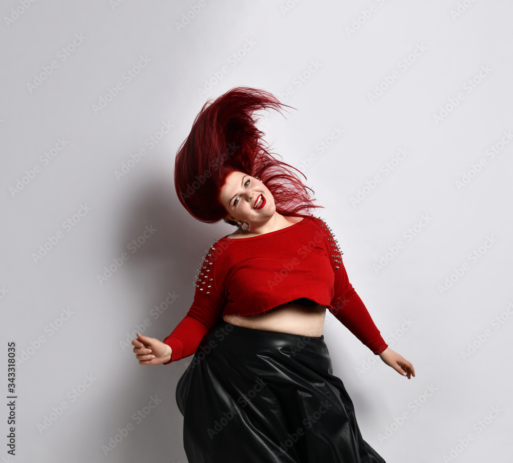 Fatty redhead model in red spiked top, black skirt. Smiling, dancing ...
