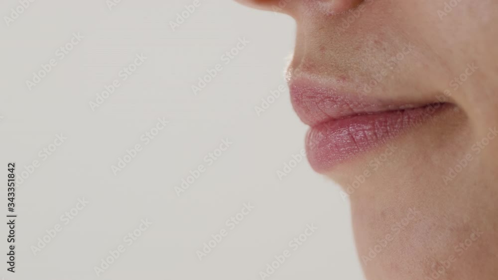 Extreme close-up of a female mouth sticking her tongue out and then ...