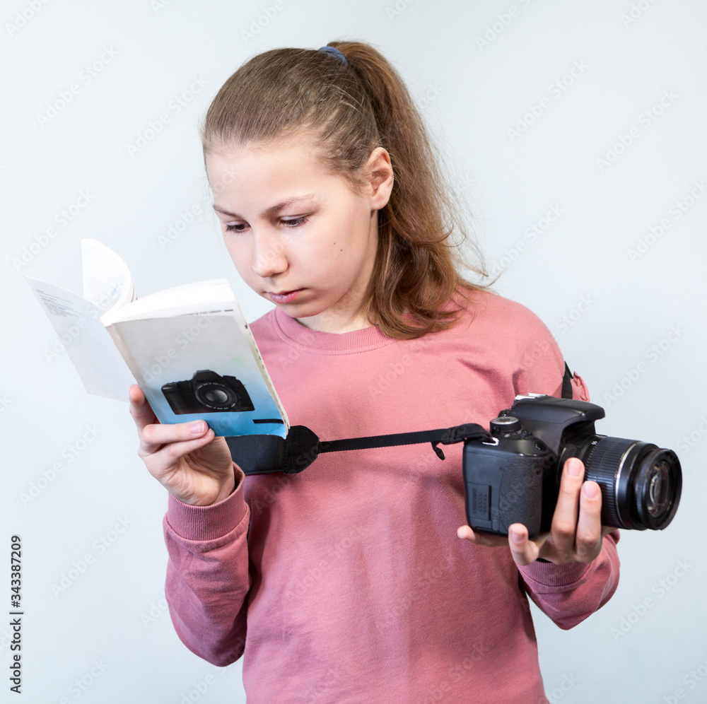 Preteen girl reading service manual book for her dlsr camera, beginner ...