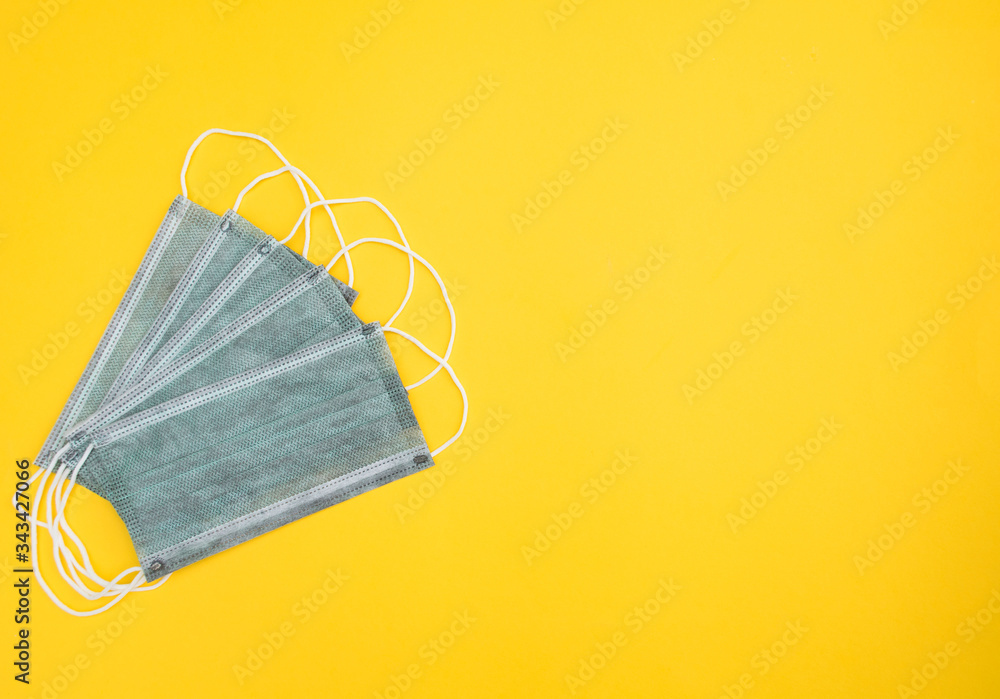 layout of medical masks on a ellow background in a horizontal position ...
